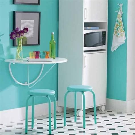 Two Stools Are In Front Of A Small White Table And Blue Wall With