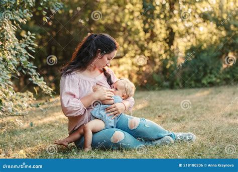 Madre Caucásica Joven Amamantando a Su Hija Bebé En Parque Al Aire