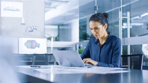 Beautiful Female Data Analyst Sitting At The Table Works On Data