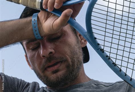Head Portrait Of The Tennis Player Male Athlete Holds Tennis Racquet