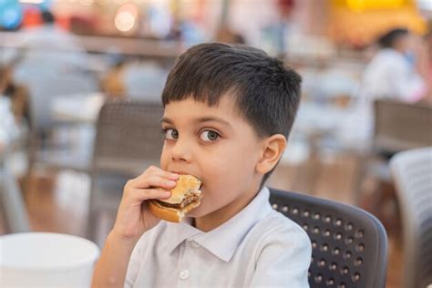 Chico Lindo Y Feliz Comiendo Hamburguesa Foto Gratis