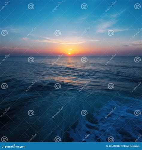 The Sun Is Setting Over The Ocean With A Wave In The Foreground Stock