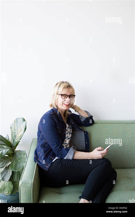 Caucasian Woman Sitting On Sofa Texting On Cell Phone Stock Photo Alamy