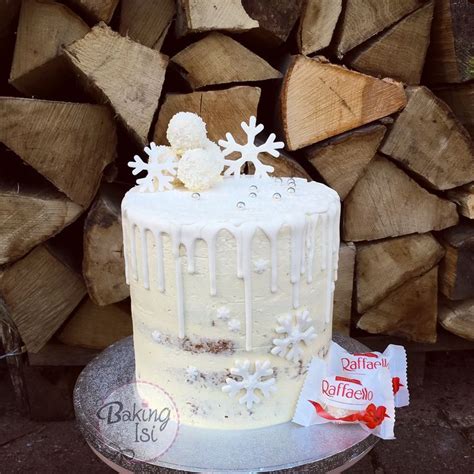 A White Frosted Cake Sitting On Top Of A Table Next To Firewood Logs