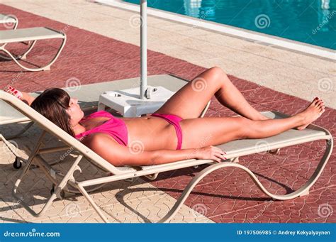 European Woman Lying On Lounge Chair Next To Swimming Pool Red Swim