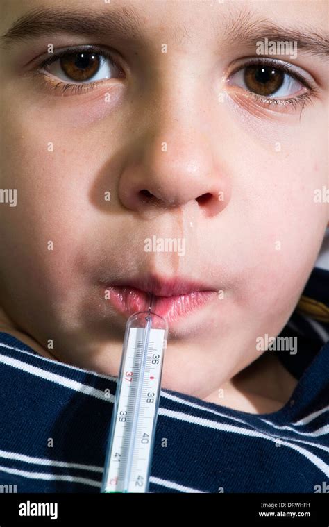 Niño enfermo en la cama Medir la temperatura con un termómetro