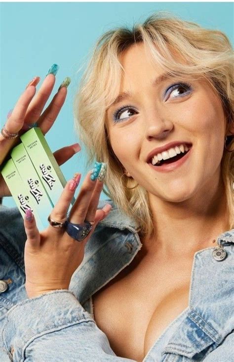 A Woman With Blue Nails Holding Up A Green Ticket In Front Of Her Face