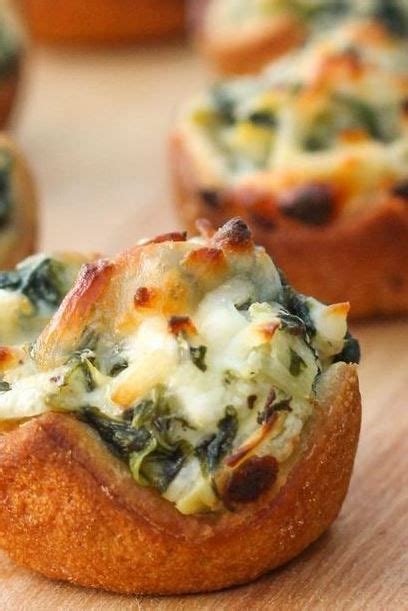 Mini Quiches Filled With Spinach And Cheese On A Cutting Board Next To