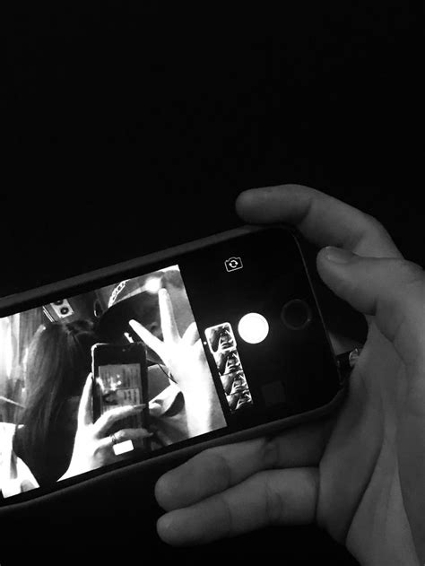 A Person Holding Up A Cell Phone To Take A Selfie With The Image On It