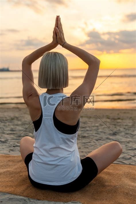 瑜伽正念和冥想概念 日落时在海滩上以莲花姿势冥想的女人瑜珈瑜伽高清摄影大图 千库网