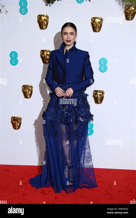 Lily Collins Poses For Photographers Upon Arrival At The BAFTA Awards