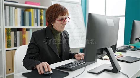 Profesora Universitaria Hispana Madura Usando Computadora En