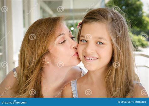 Madre Che Bacia Sua Figlia Nella Guancia Immagine Stock Immagine Di