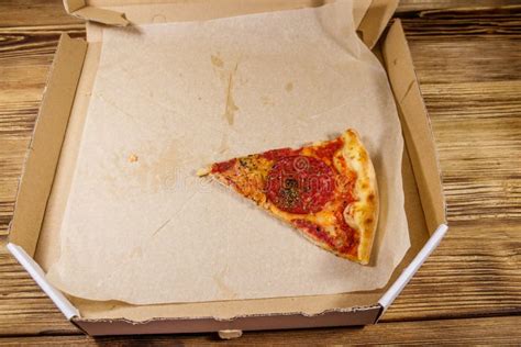 Last Slice Of Pizza In Cardboard Box On Wooden Table Concept For Home