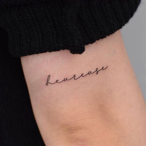 Heureuse Lettering Tattoo On The Tricep