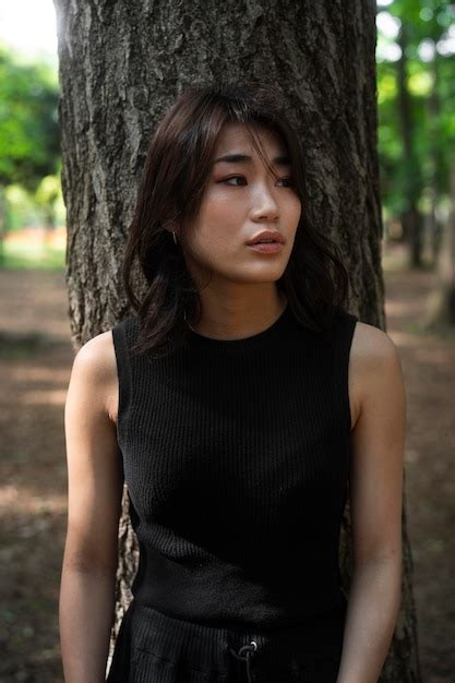 Mujer japonesa de tiro medio cerca del árbol Foto Gratis