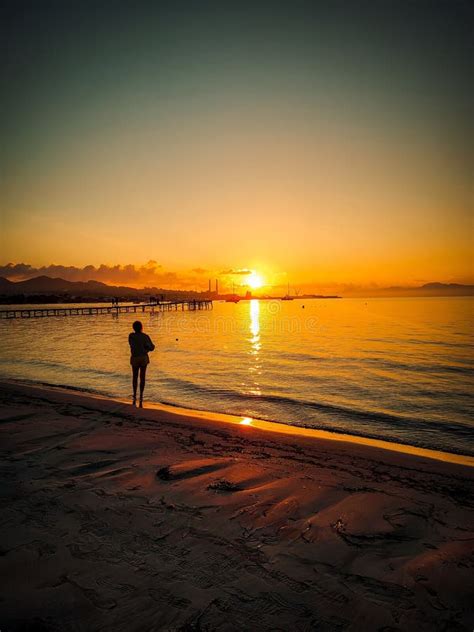 Silueta De Humanos Parados Frente Al Mar Durante La Puesta De Sol Foto