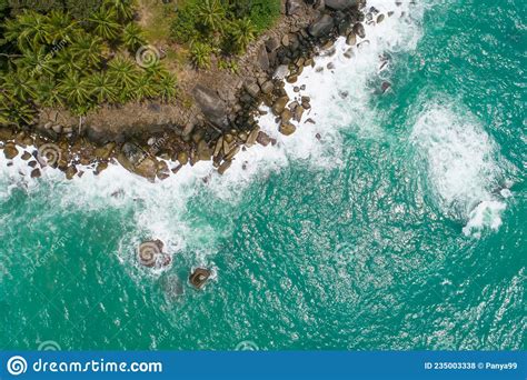 Aerial Top View Of Sea Waves Crashing On Rocks With Coconut Palm Trees