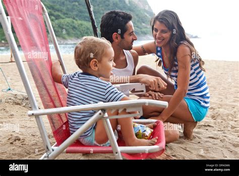 Jeune famille assise sur la plage Banque de photographies et dimages à