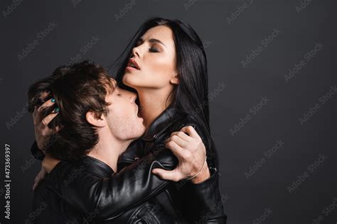 Passionate Man Kissing Neck Of Seductive Woman Isolated On Grey Stock