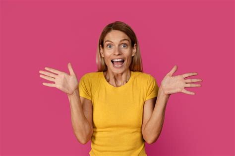 Premium Photo Glad Happy Shocked Middle Aged European Blonde Lady With Open Mouth Spreads Her