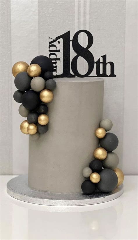 A Birthday Cake Decorated With Black White And Gold Decorations