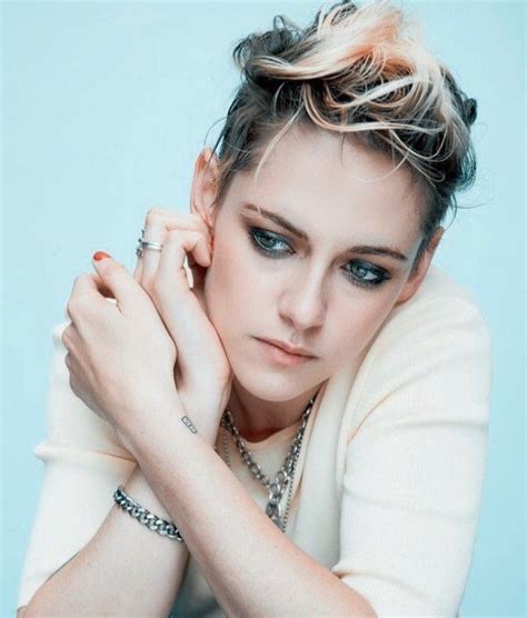 A Woman Sitting At A Table With Her Hand On Her Chin And Looking Off To