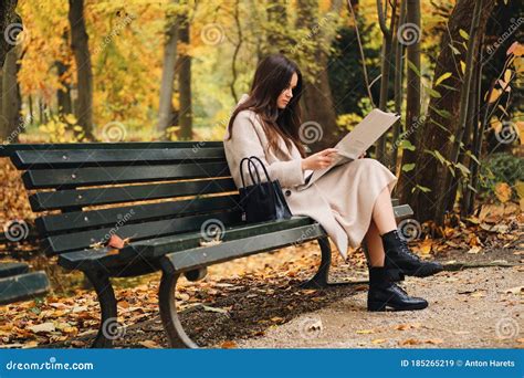 Side View Of Attractive Brunette Girl Intently Reading Newspaper
