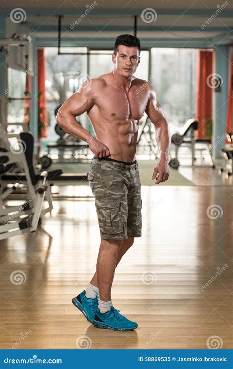 Homem No Gym Que Mostra Seu Corpo Bem Treinado Imagem De Stock Imagem