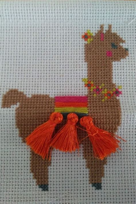 A Cross Stitch Llama With Tassels On It S Back