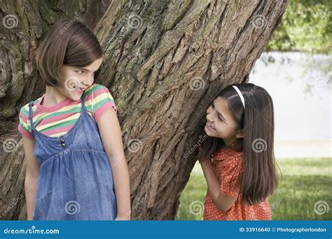 Filles Jouant Le Cache Cache Par L Arbre Photo Stock Image Du