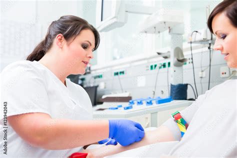 Krankenschwester legt Zugang für Blutentnahmen und Spritzen am Oberarm