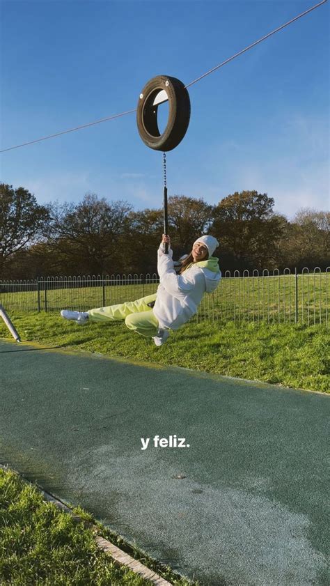 A Woman Hanging Upside Down On A Rope In The Grass With An Object