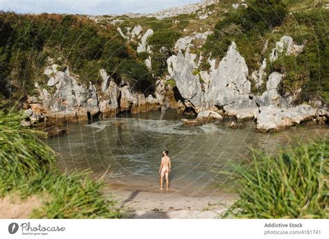 Unrecognizable Naked Man Standing On Lakeside In Rocky Highlands A