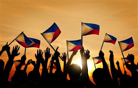 Group Of People Waving Filipino Flags In Back Lit Free Image By