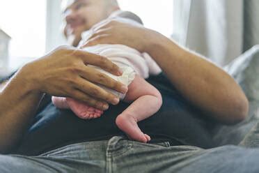 Naked Mother Comforting Naked Baby Resting Against Her Chest Stock Photo