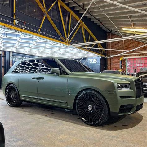 A Green Rolls Royce Parked In A Garage