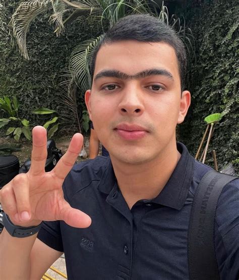 A Man Making The Peace Sign With His Hand