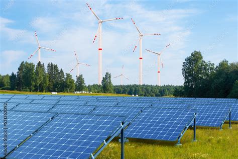 Solar Panels Under Windmills Wind Power Plants In Sunny Weather