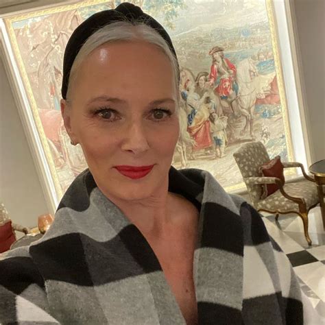 An Older Woman With Grey Hair Wearing A Black And White Checkered Coat