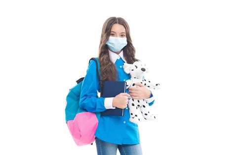 Niño de la escuela con máscara médica protectora aprende y juega con un