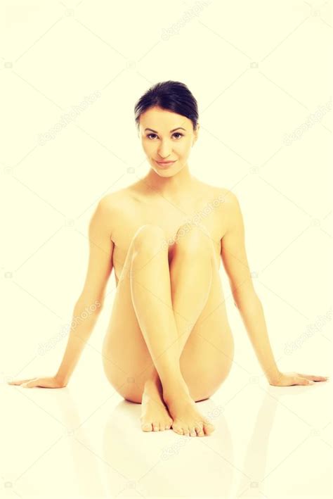 Vista frontal mujer desnuda sentada apoyando el piso fotografía de