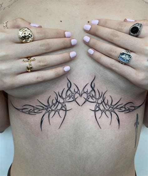 A Woman S Chest With Tattoos On It And Her Hands In The Shape Of Two Wings