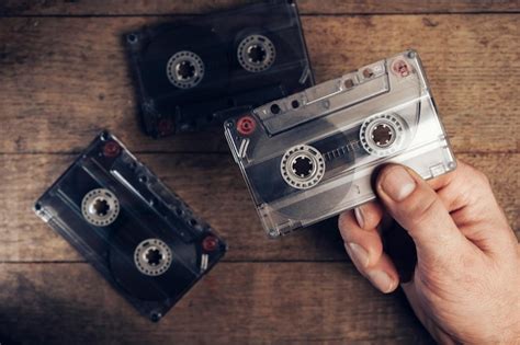 Premium Photo Hand Holding Audio Cassette Tape On Brown Old Wooden
