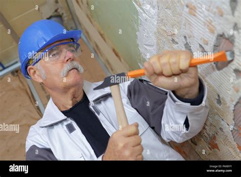 Senior Builder Using Hammer And Chisel Stock Photo Alamy