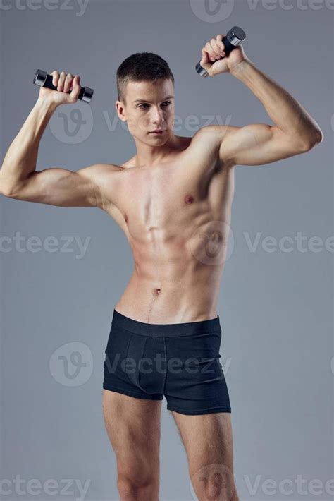 atlético muscular hombre con muscular cuerpo pesas en el manos de