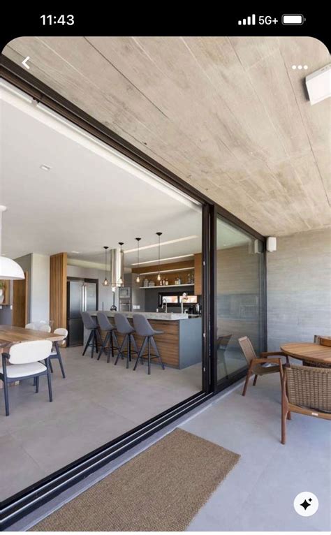 An Open Glass Door Leading To A Dining Room And Kitchen Area With