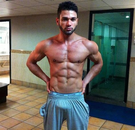 A Shirtless Man Standing In A Bathroom With His Hands On His Hips And