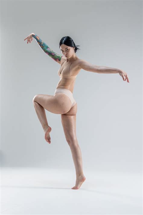 A Naked Woman Is Posing With Her Leg In The Air And Arms Out To Side