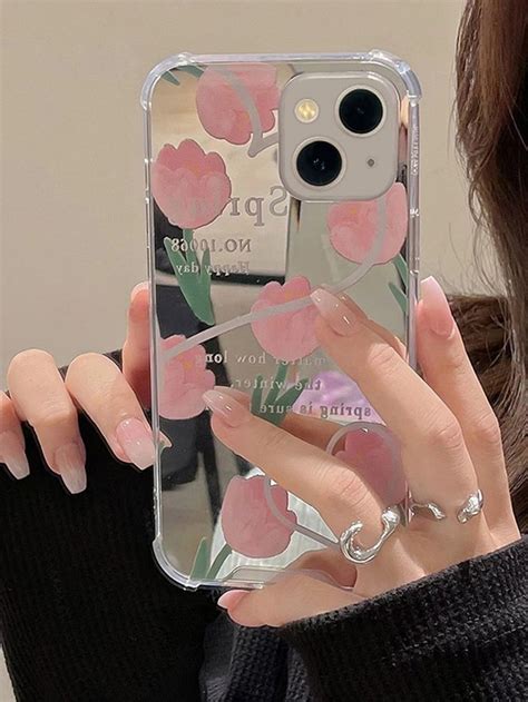 A Woman Holding Up Her Phone Case With Pink Flowers On The Front And